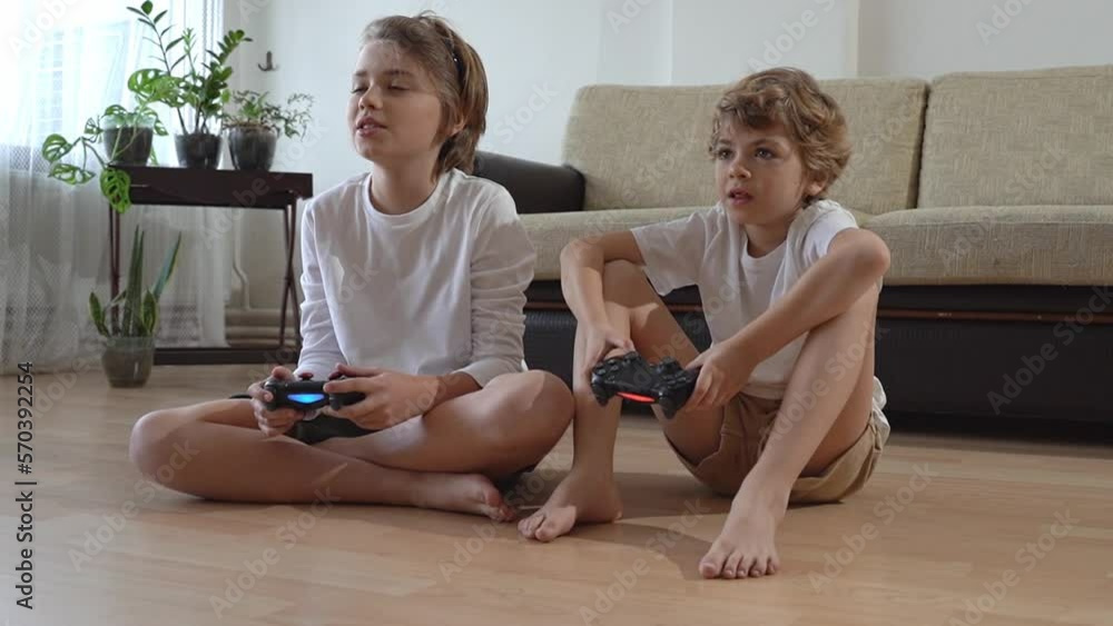 Gamer Children siblings playing video games in front of tv, using ...