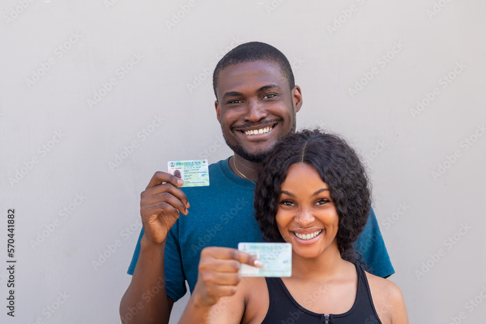 Two Nigerian citizens, male and female holding their voters card, PVC ...