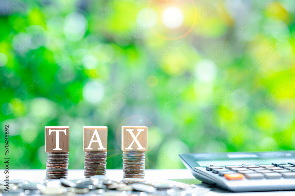Tax concept, Wooden cube with tax text on coins and calculator on desk ...