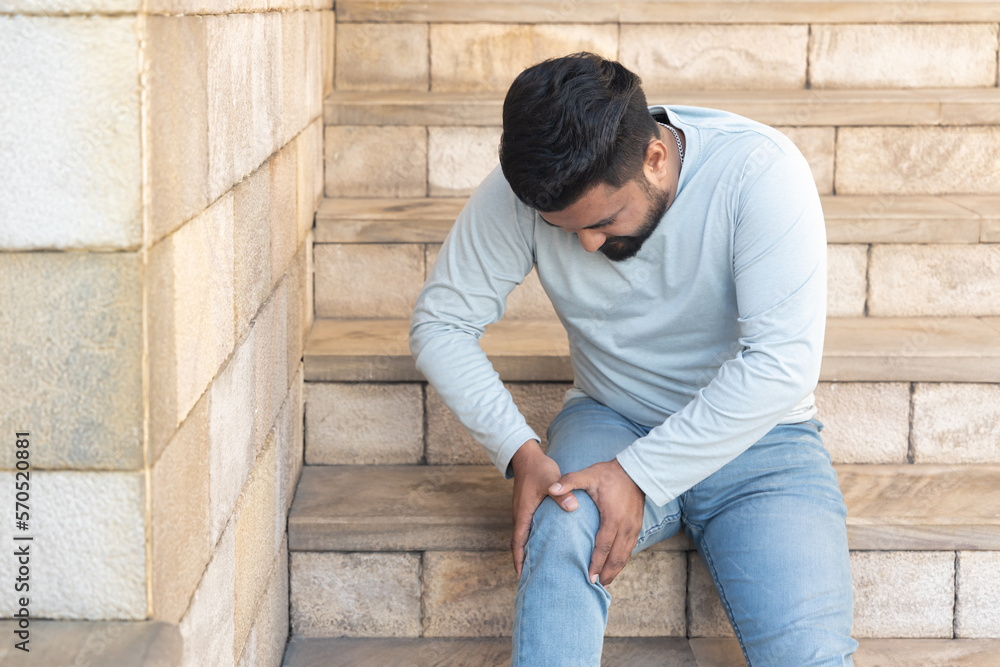 South Asian man falling down from stair, hurting his leg and knee joint ...