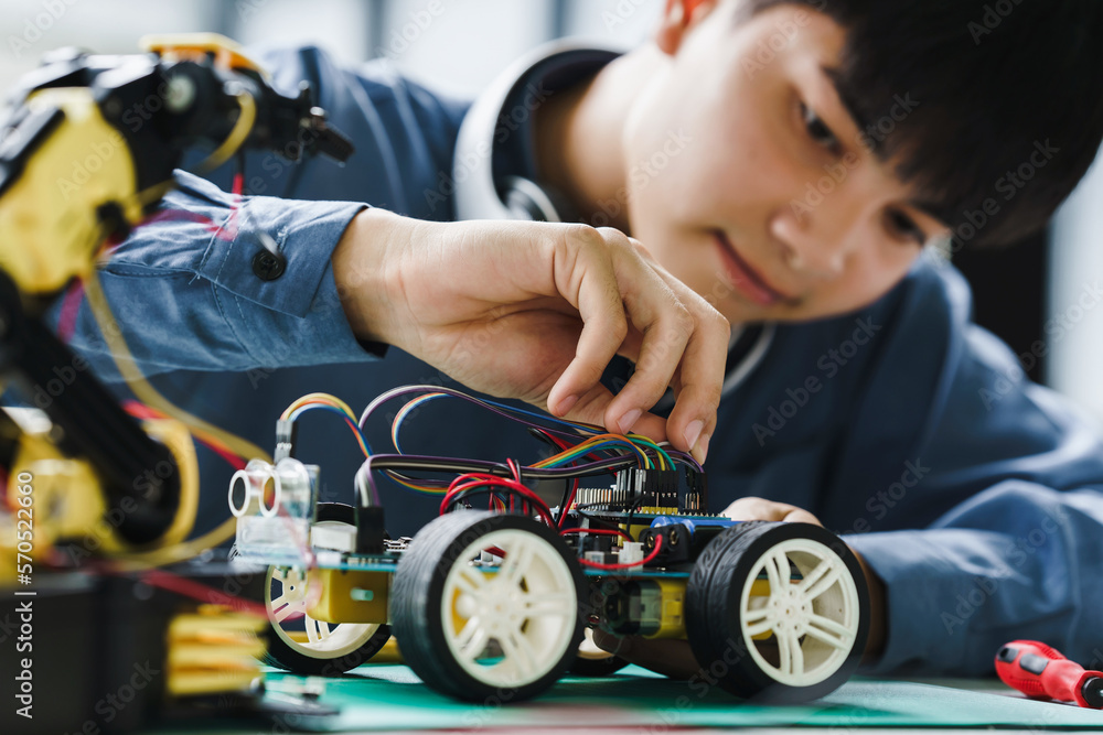 Asian teenager students doing robot arm and robotic cars homework ...