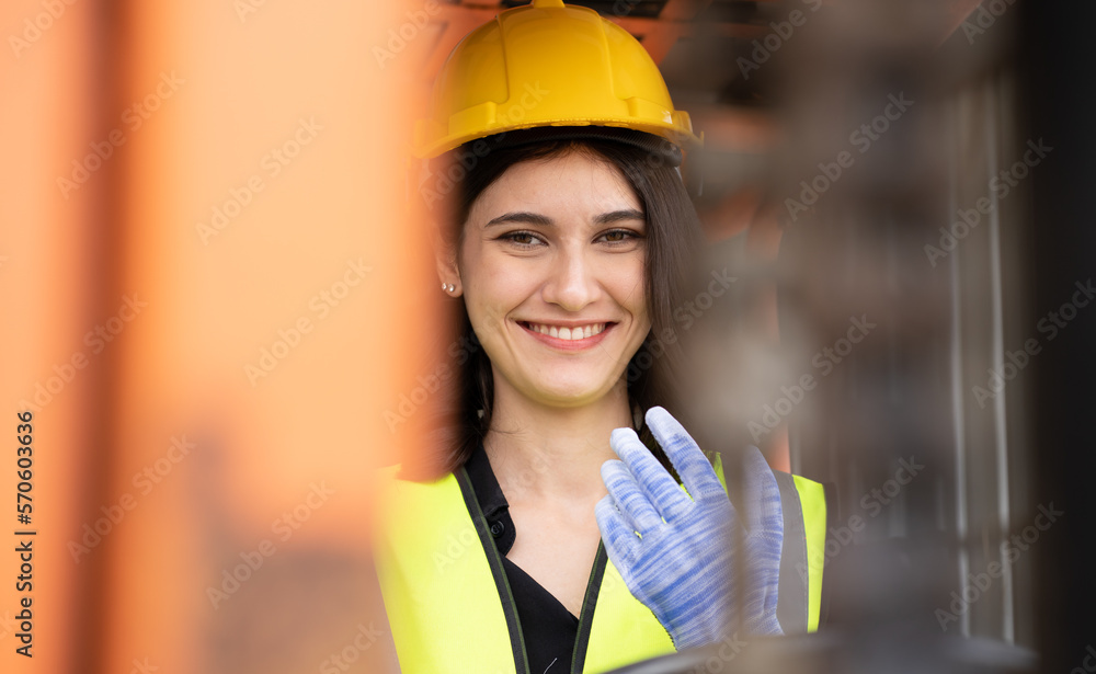 Female foreman using radio while driving forklift vehicle at shipping ...