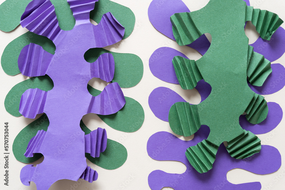 overlapping folded and cut green and purple paper shapes in the form of ...