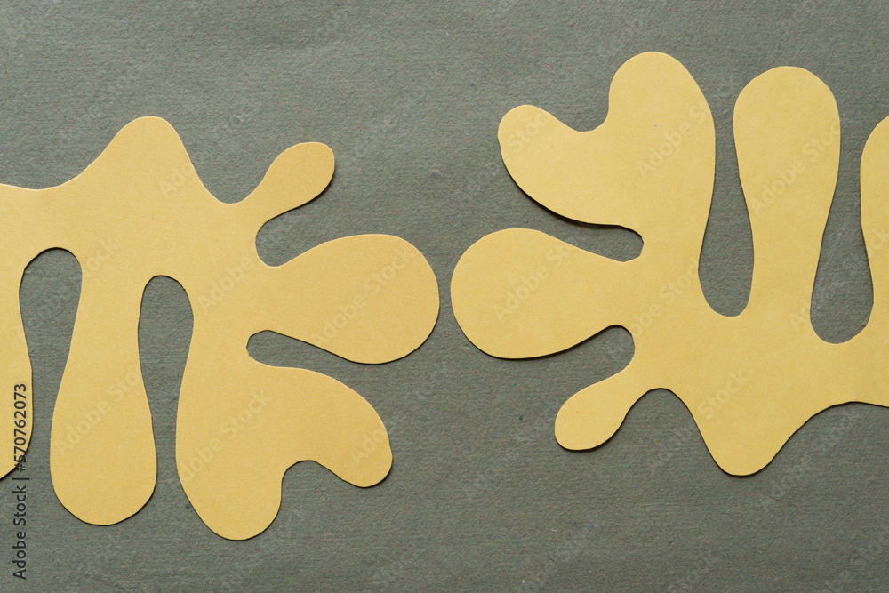 two nearly identical cut yellow paper shapes (polyp, columnar, organic ...