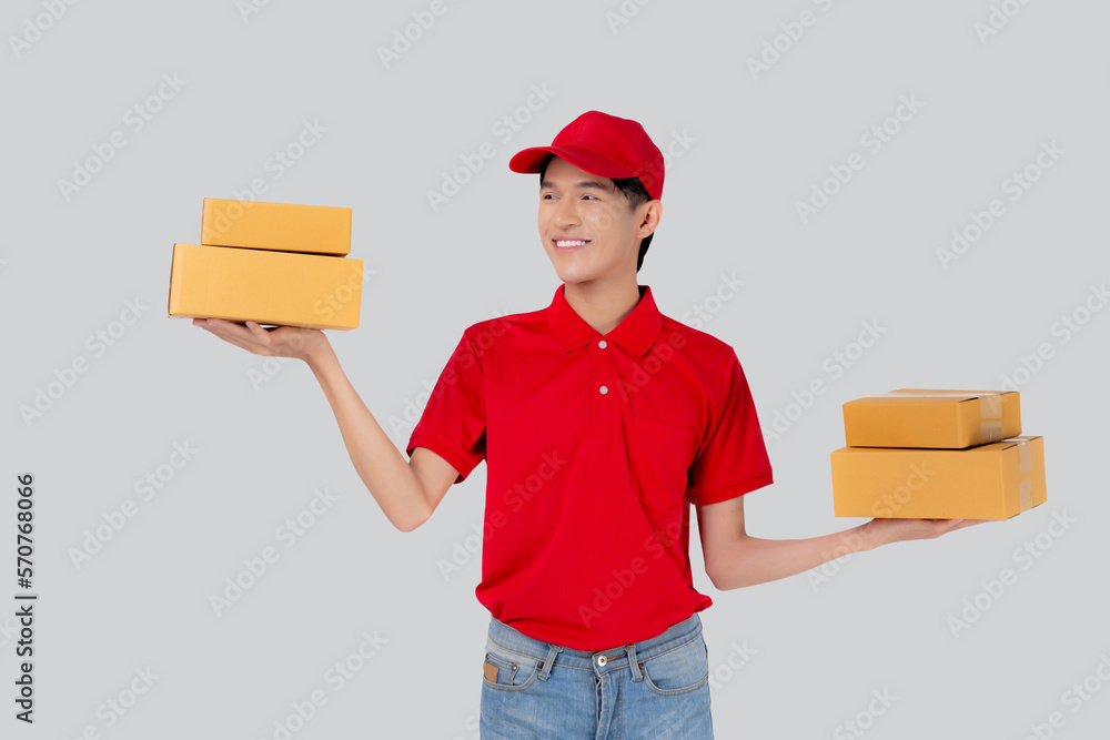 Young asian man in uniform red and cap standing carrying box stack ...