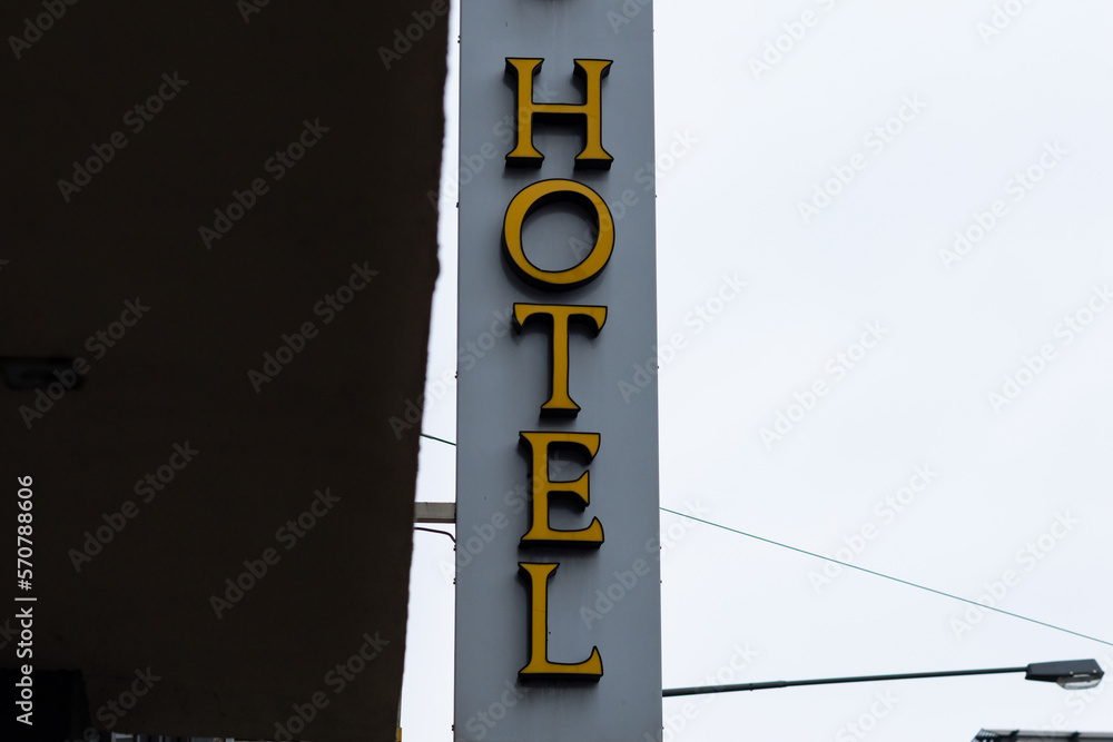 Hotel sign on a building. Yellow letters on a grey background ...