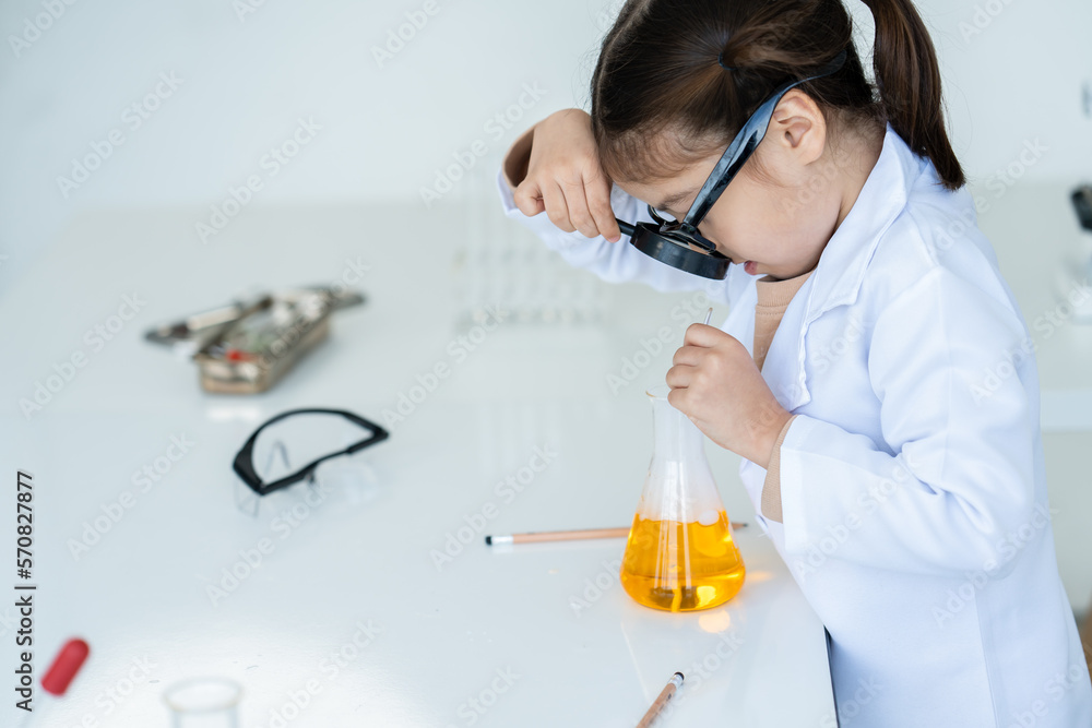 Adorable Arab school girl holding flask while doing chemistry ...