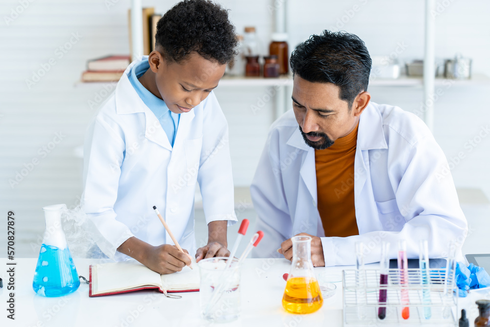 Foto de Science teacher teaches a male student of African descent to ...