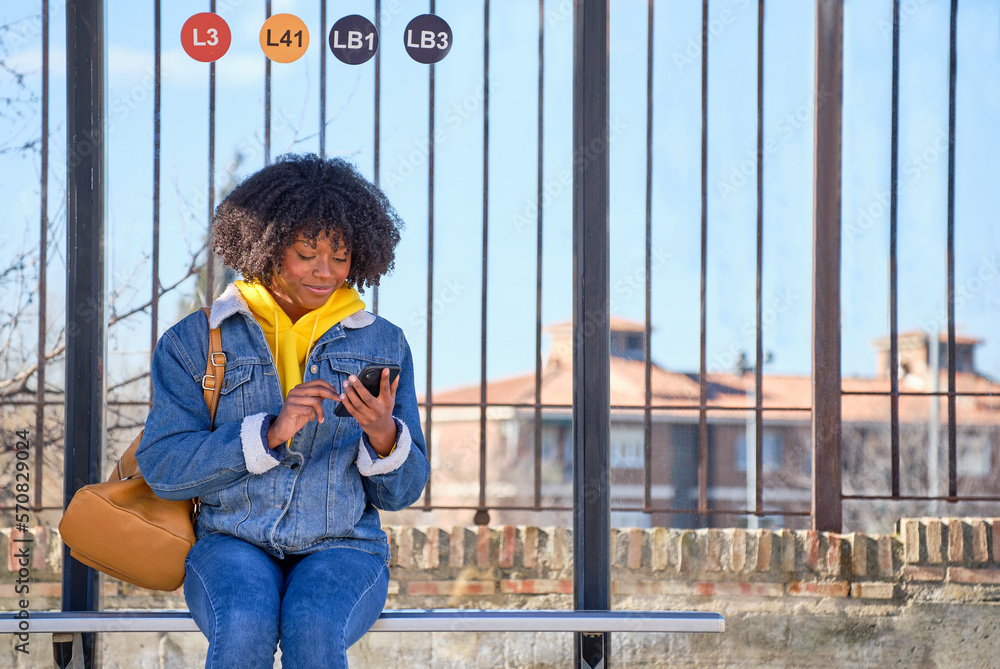 young black girl with afro hair sitting at a bus stop waiting looking ...