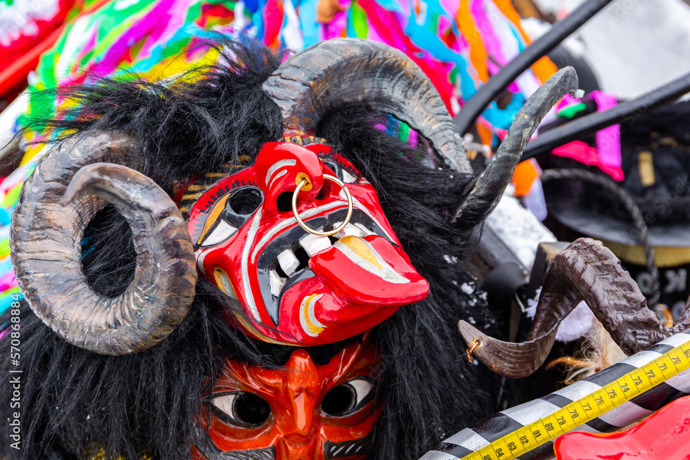 Traditional wooden mask of a devil with horns and tongue during Gody ...