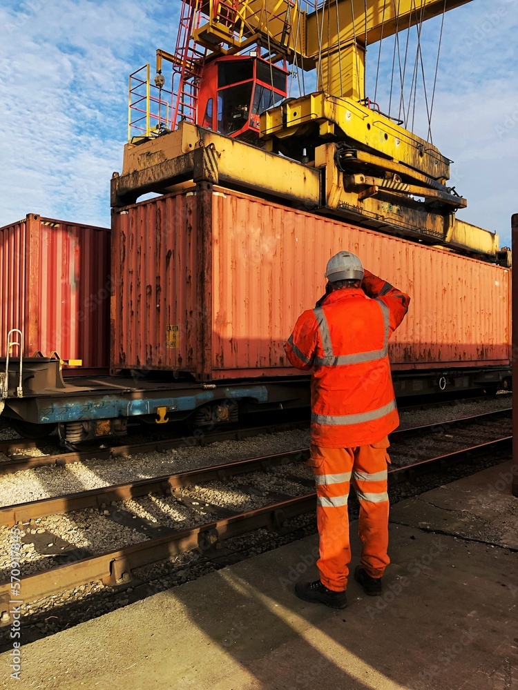 Rail worker loading shipping containers onto freight train Stock Photo ...