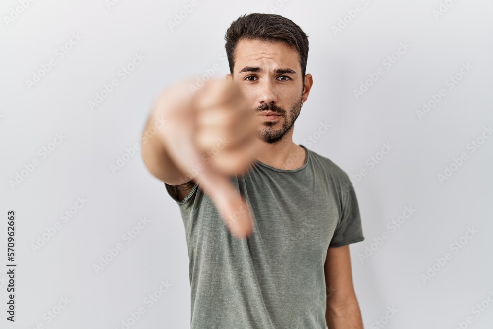 Young hispanic man with beard wearing casual t shirt over white ...