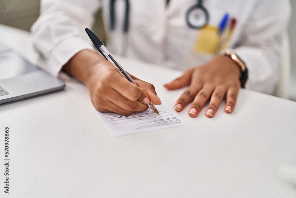 African american woman doctor writing on covid-19 vaccination record ...