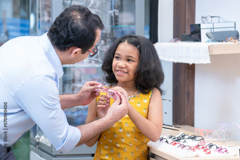Indian cute little daughter and father are choosing appropriate ...