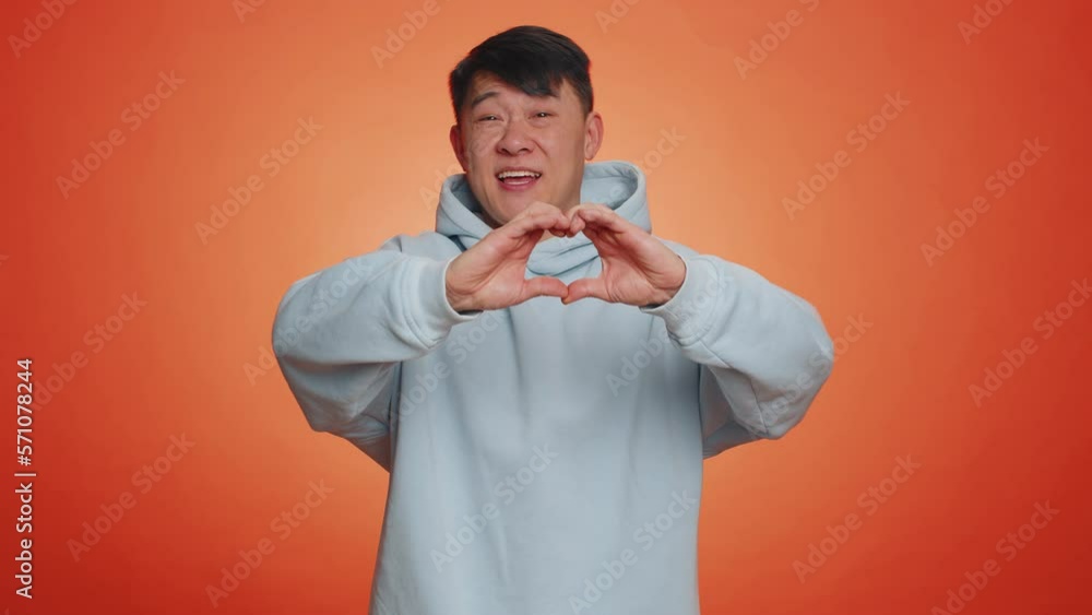 Man in love. Smiling asian man 40 years old makes heart gesture ...