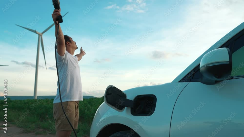 Progressive man with his electric car, EV car recharging energy from ...