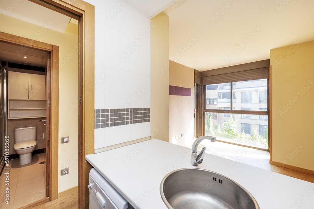 apartment kitchen with white cabinets with matching countertop, pass ...