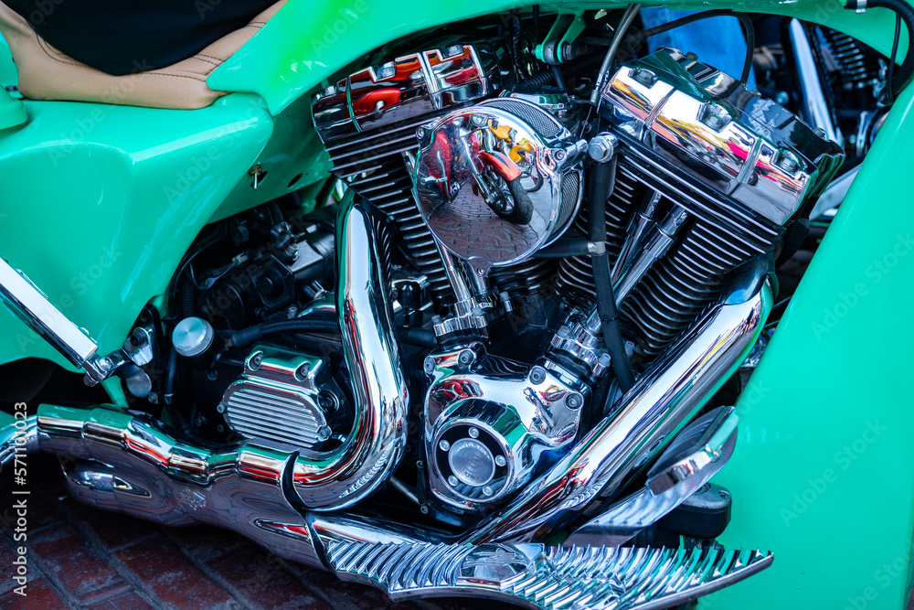 Green motorcycle with its chrome engine reflecting another motorcycle ...