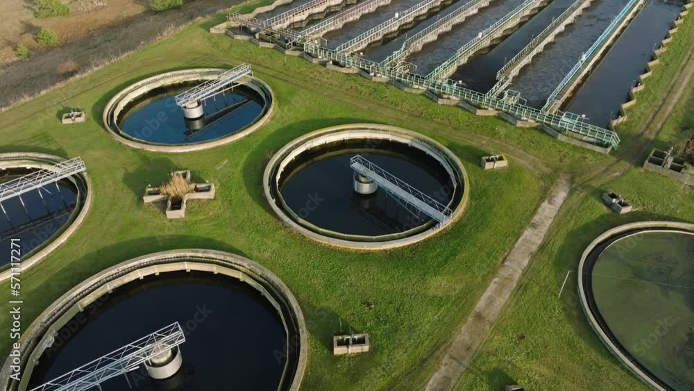 Aerial establishing view of water basins at sewage treatment plant ...