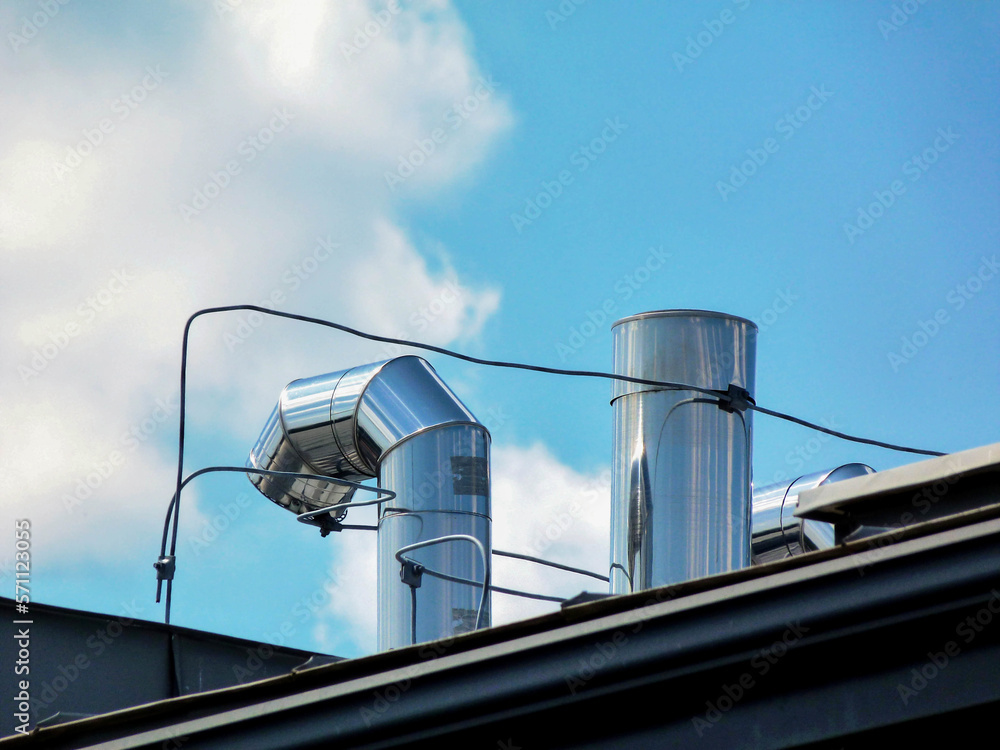 shiny stainless steel mechanical air vents and ducts on sloped roof ...