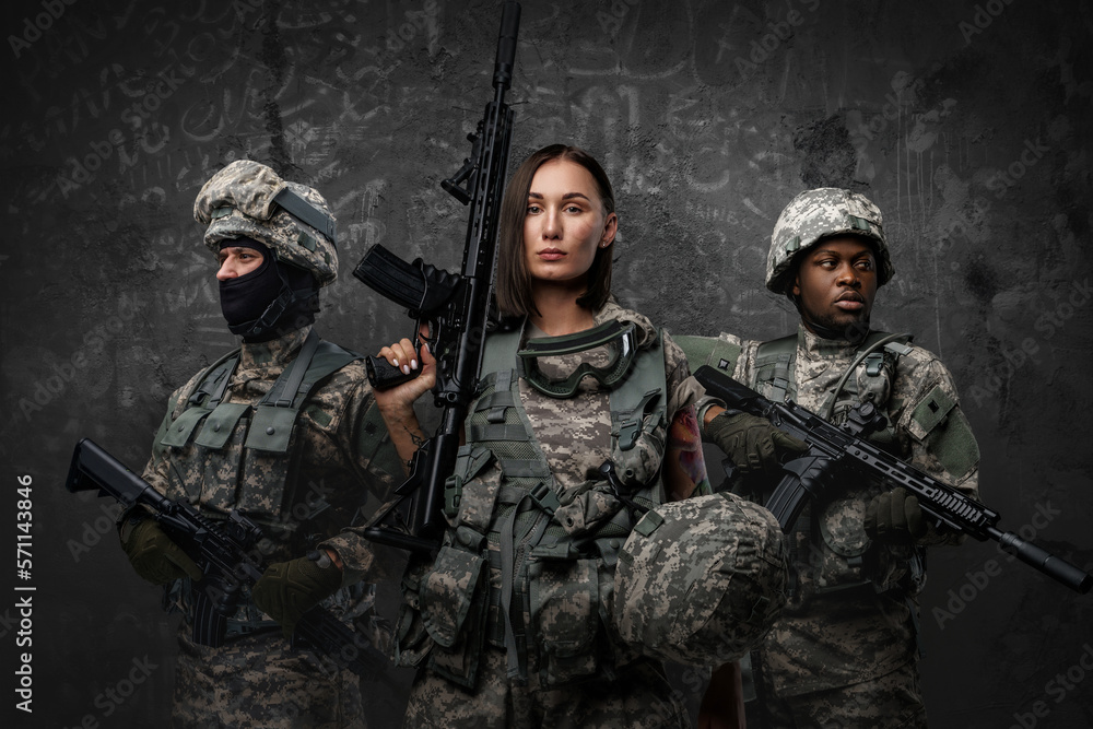 Shot of multiethnic squad of soldiers dressed in modern uniforms armed ...