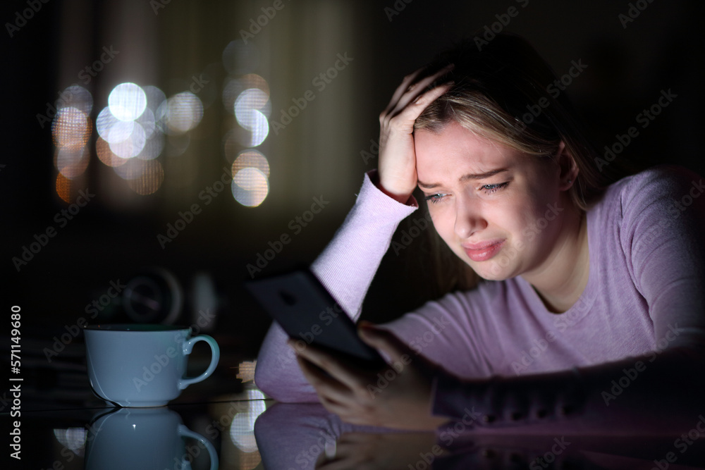 Sad teen crying checking phone in the night Stock Photo | Adobe Stock