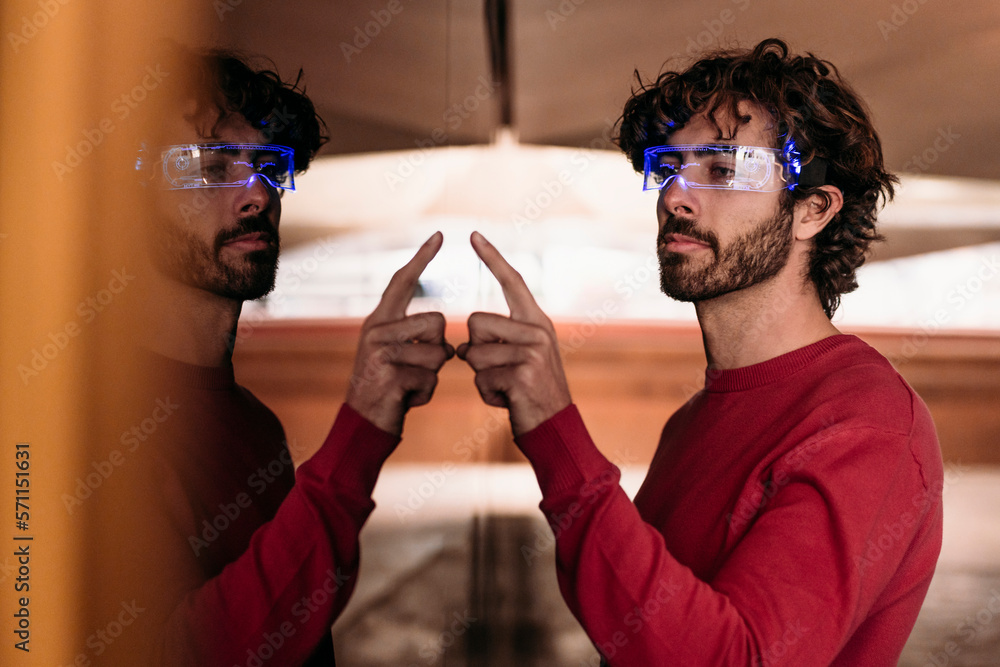 Man wearing smart eyeglasses using touch screen in underground walkway ...
