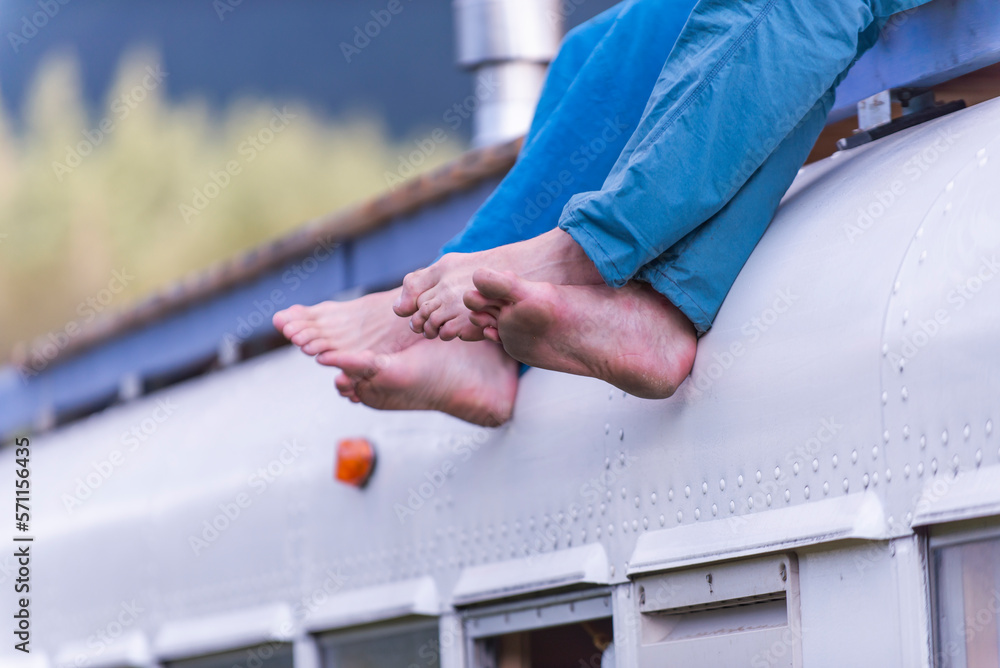 side view of bare feet hanging from roof of school bus two people Stock ...