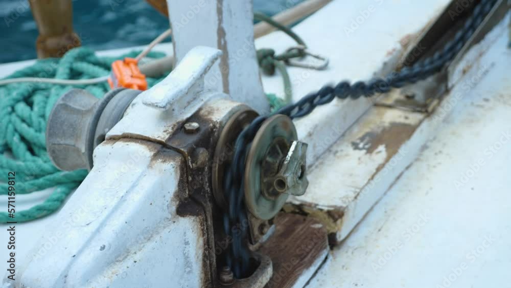 Anchor chain sliding on tensioning pulley on the bow of the yacht while ...