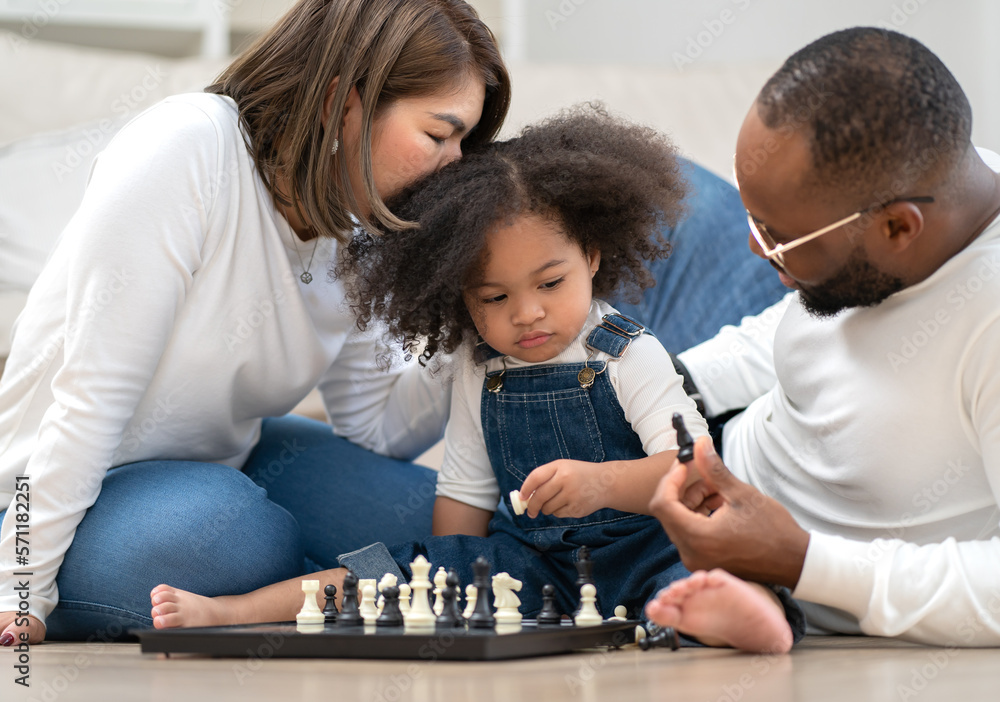 Cute little girl playing chess board as her father sitting by ...