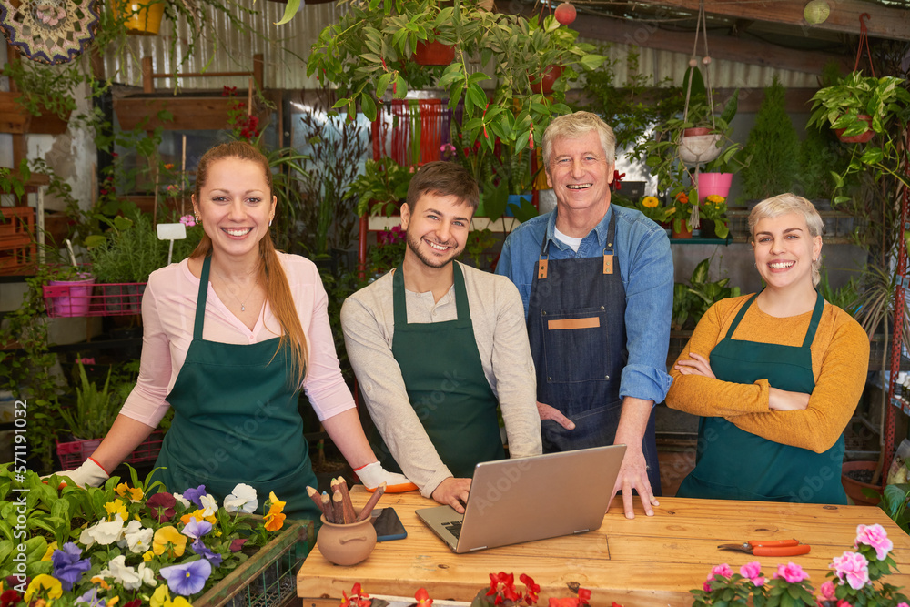 Satisfied gardening team in the flower shop at the laptop Stock Photo ...