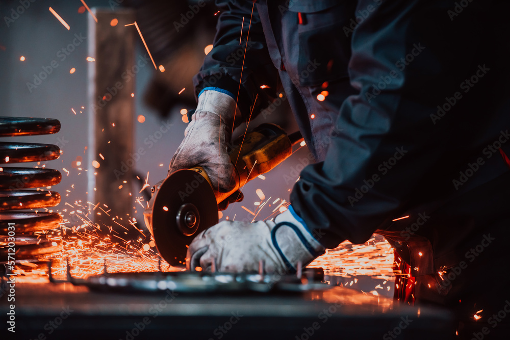 Locksmith in special clothes and goggles works in production. Metal ...