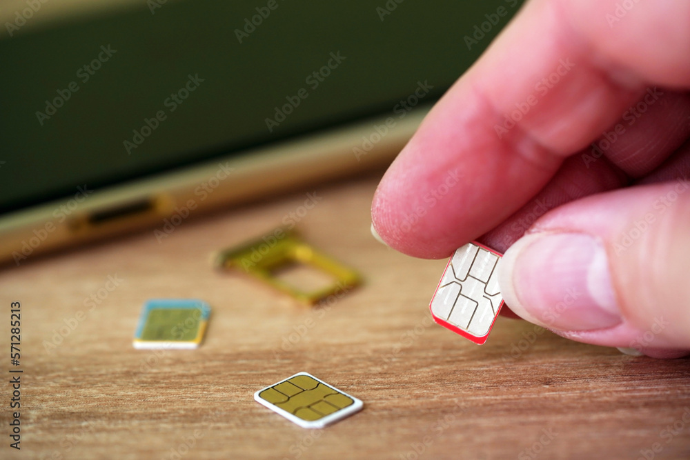 Foto de Person inserting a sim card into back of mobile phone, Sim card ...