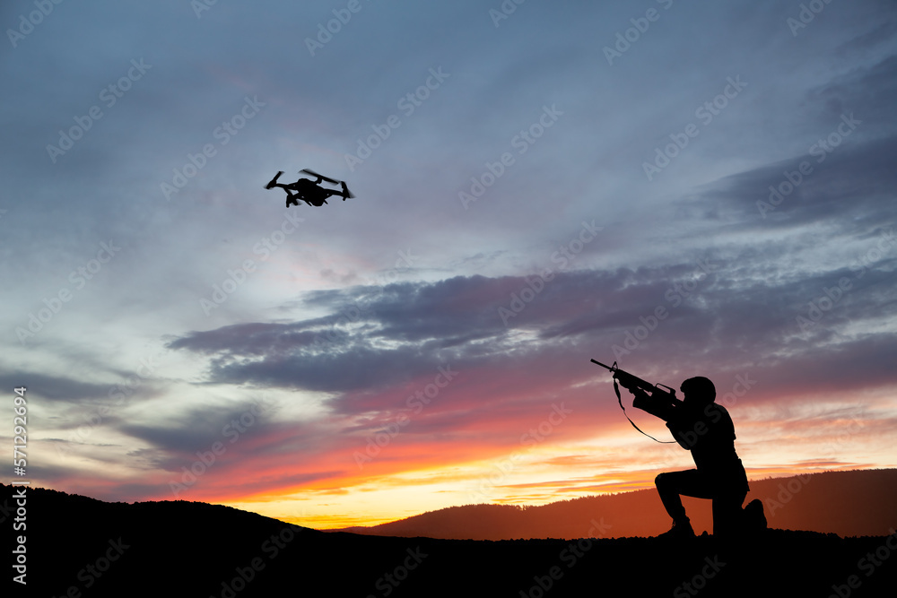 Soldier trying to shoot down reconnaissance drone against the backdrop ...