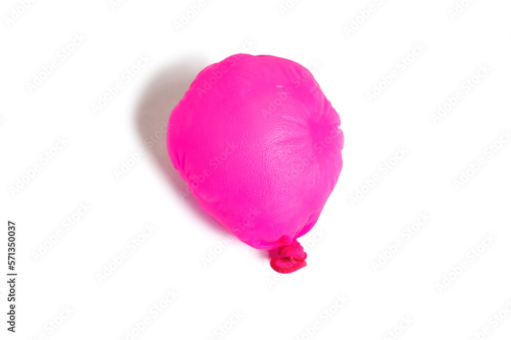 Half deflated pink balloon on a white background. One uninflated ...