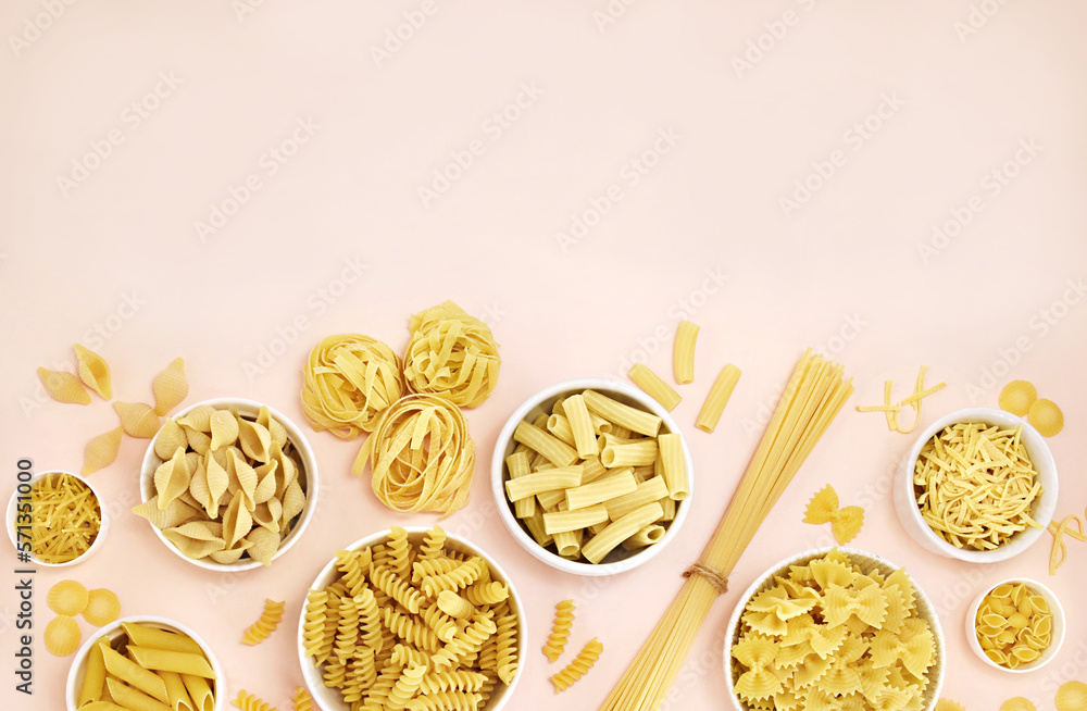 Mix of pasta shapes varieties on pink background: penne and fusilli ...
