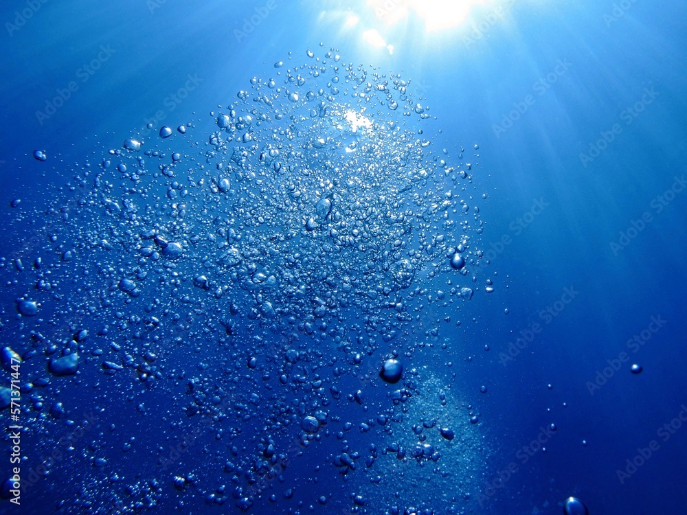 Foto de Bright exhale bubbles from scuba diver and sun in the blue ...