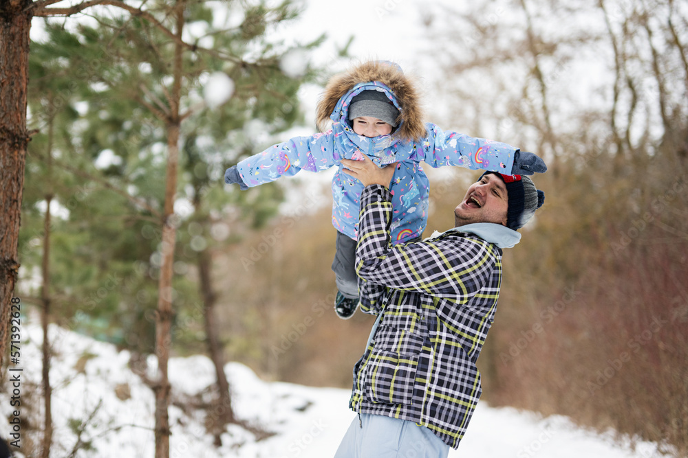 Daughter on a piggy back ride with her dad in winter forest. Stock ...