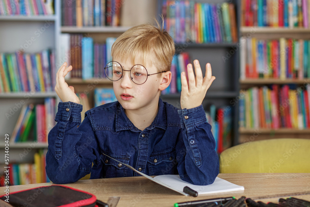 Child boy writes and draws in school or library. Bookstore concept ...