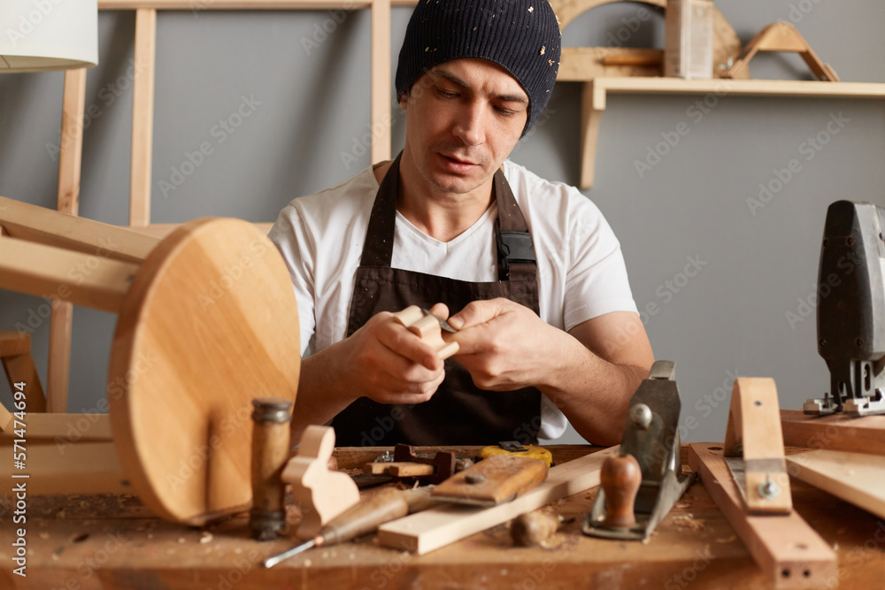 Foto de Portrait of concentrated young adult man carpenter wearing ...