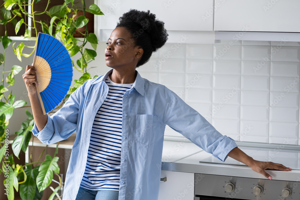 Overheating concept. African American woman fanning herself with hand ...