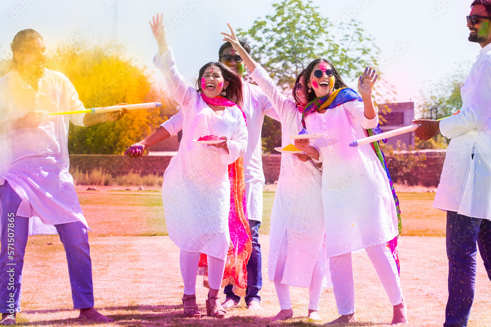 Group of happy young Indian people celebrating holi festival at park ...