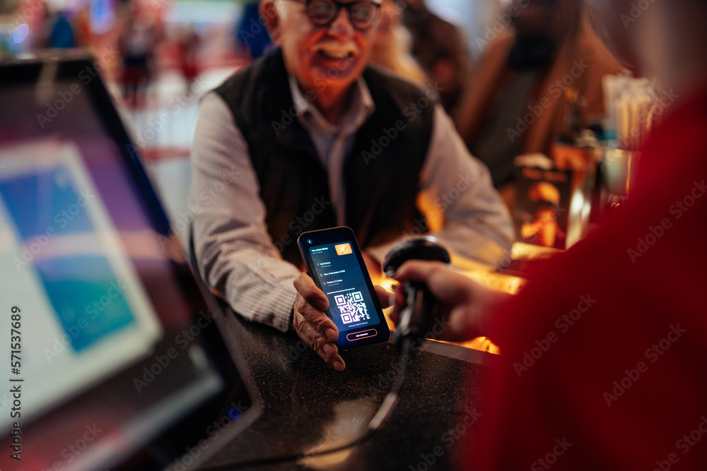 Cashier scanning qr code on mobile app. Stock Photo | Adobe Stock