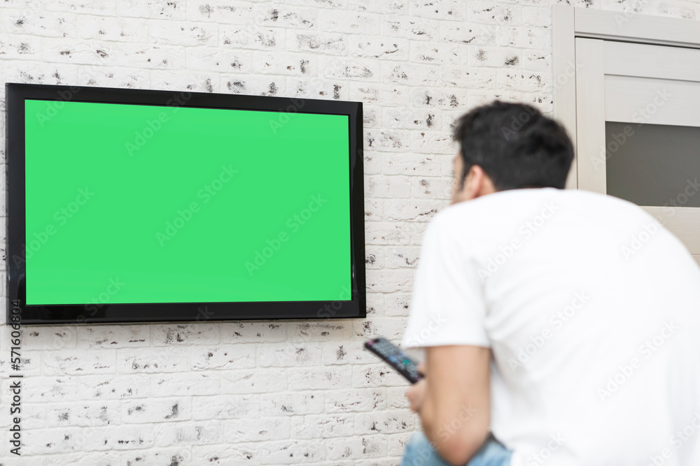 Shocked man on the couch watching tv. Bad news and Green screen concept ...