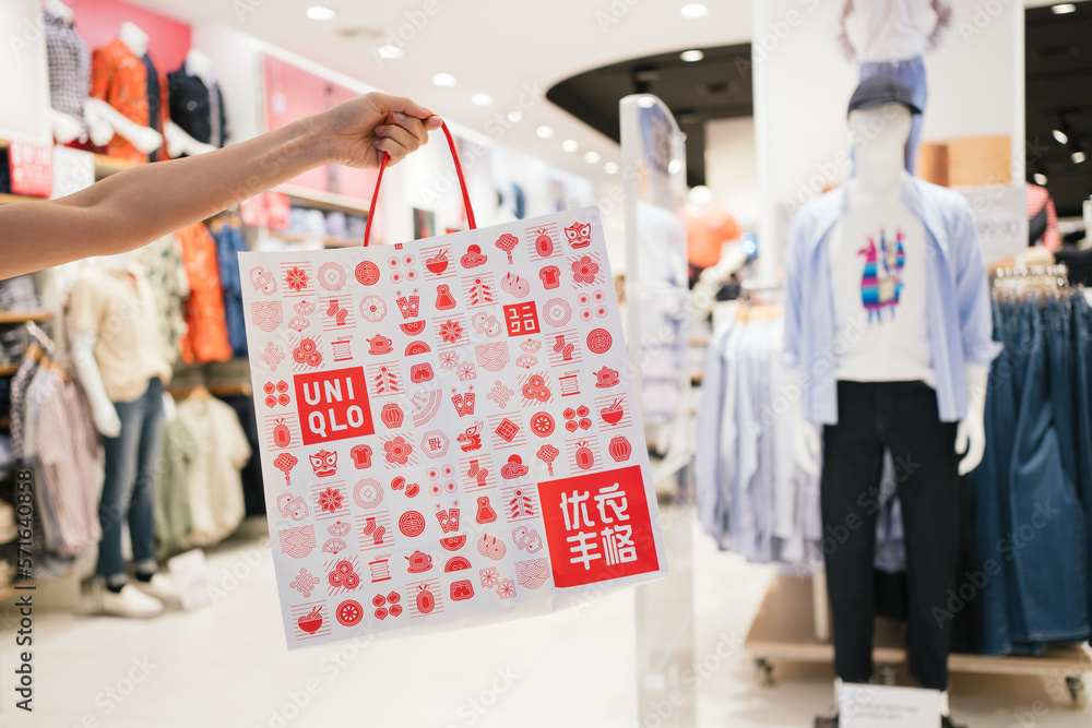 PENANG, MALAYSIA - JAN 10, 2020: Lady holding Uniqlo paper bag with ...