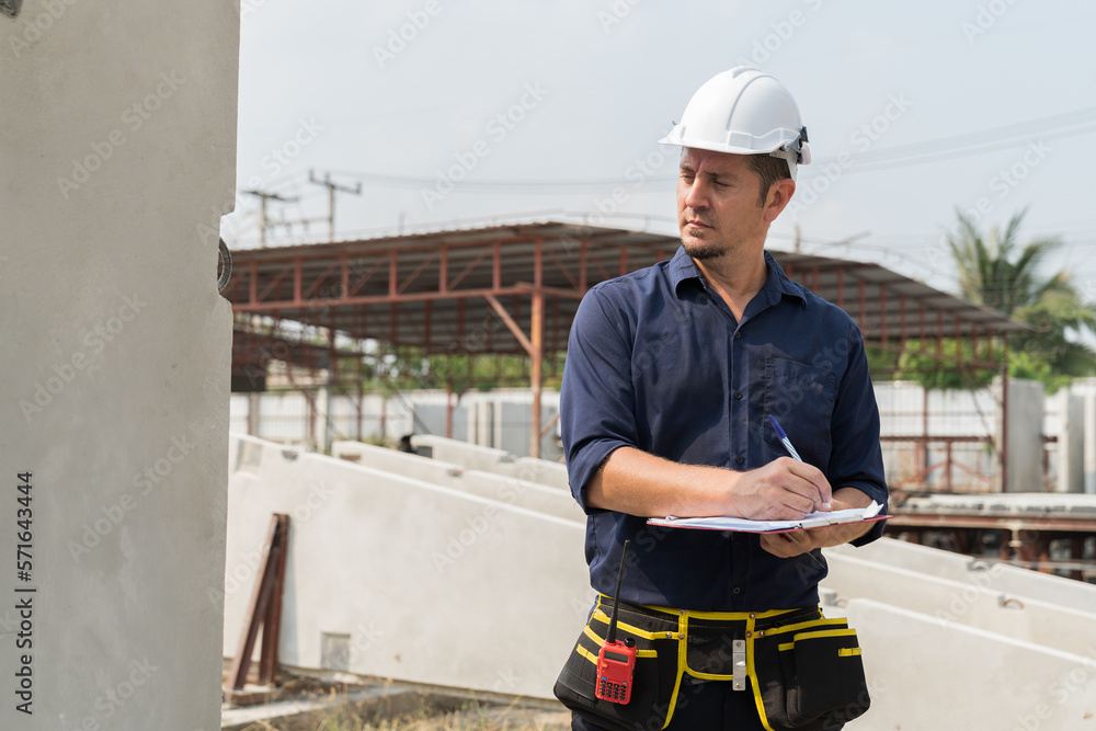 Foreman builder inspecting precast concrete wall structure quality at ...