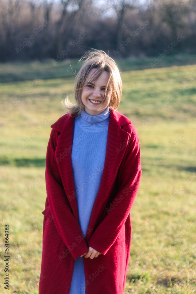 Fotografia do Stock: Girl in a red coat.The girl sincerely laughs and ...