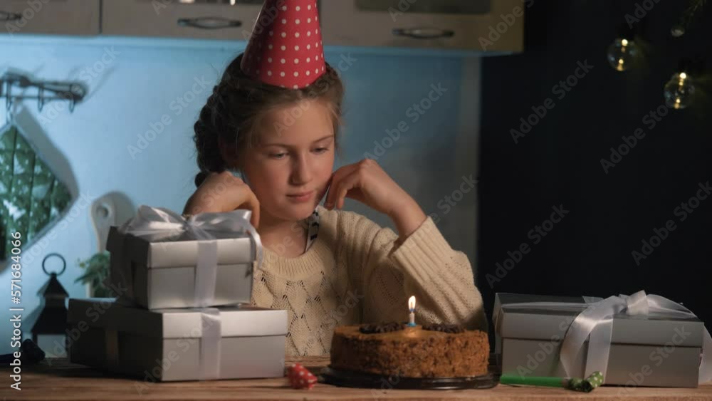 lonely sad child sits alone at home on his birthday. girl during pandemic on her birthday ...