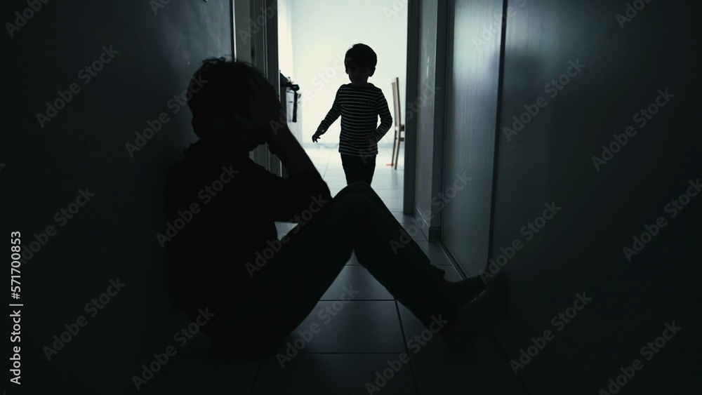 Depressed father being consoled by son sitting in corridor in ...