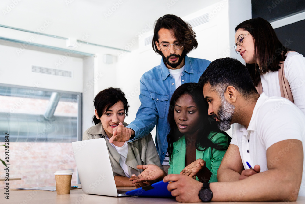 Group of multiracial colleagues work together on a project ...